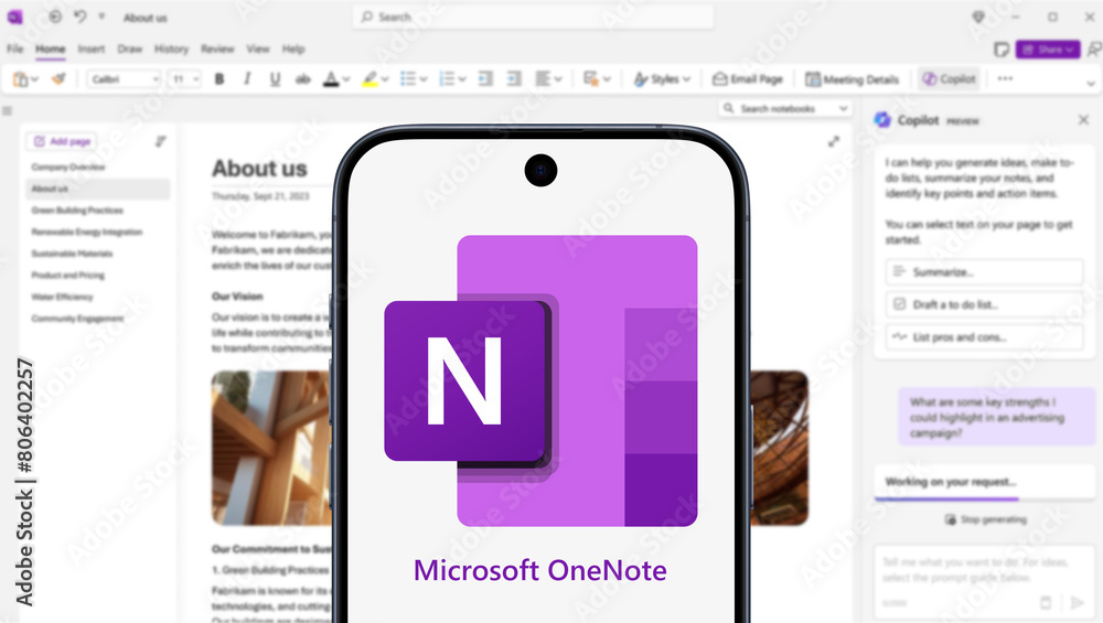 OneNote logo displayed on a modern smartphone standing on a desk ...
