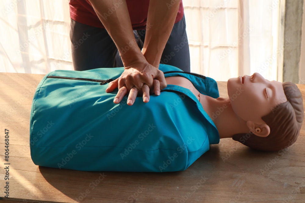instructor guides an adult in CPR training, importance of first aid ...