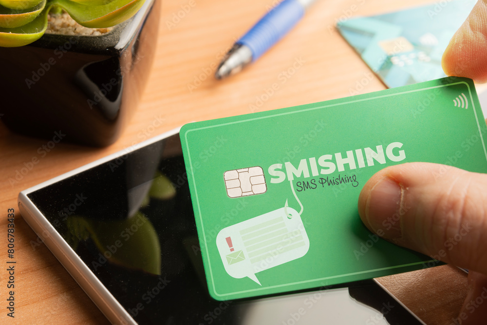 Smishing (SMS message phishing) concept: man hold a credit card over a ...