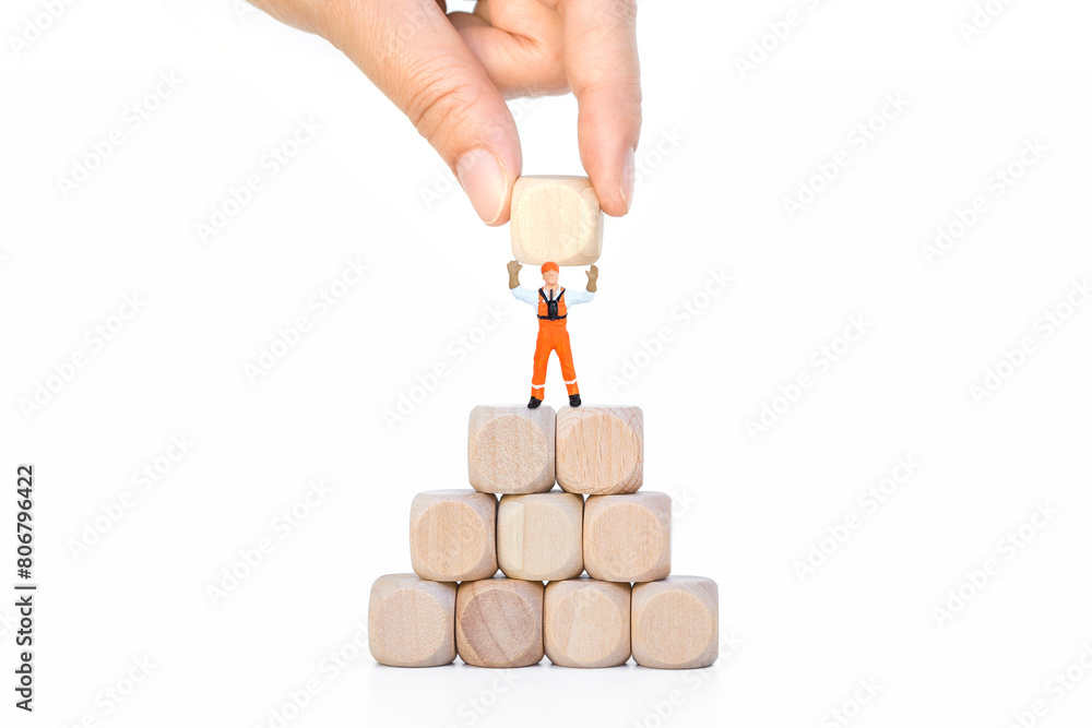 Miniature worker on stack of wooden cube isolate on white background ...