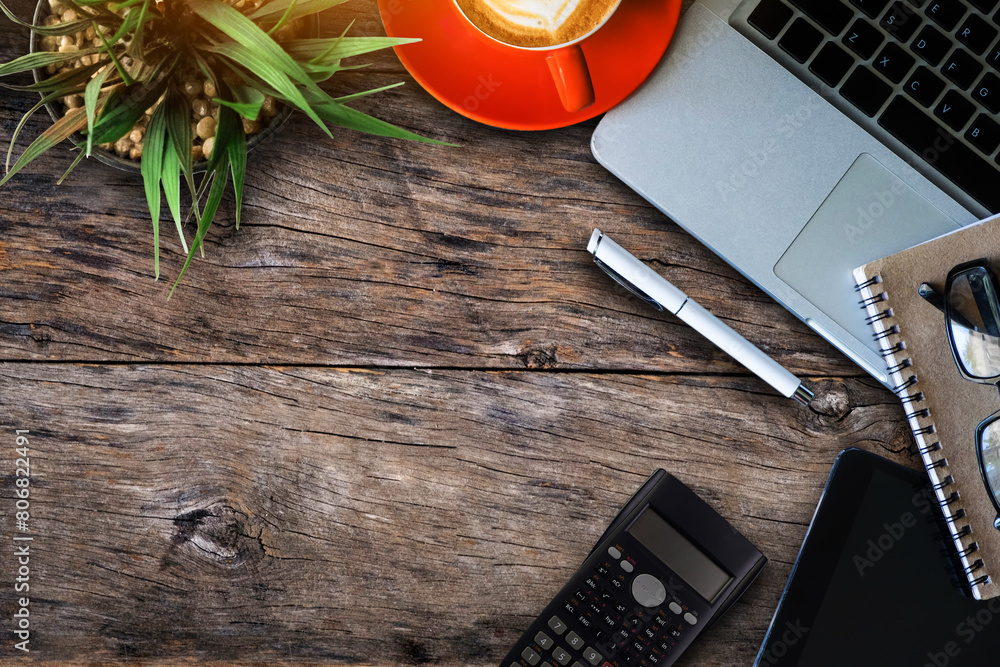 Laptop and tablet are on top of office desk table with cup of latte ...