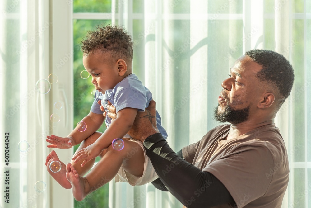 Happy african black parents dad father throw baby son on piggyback and ...