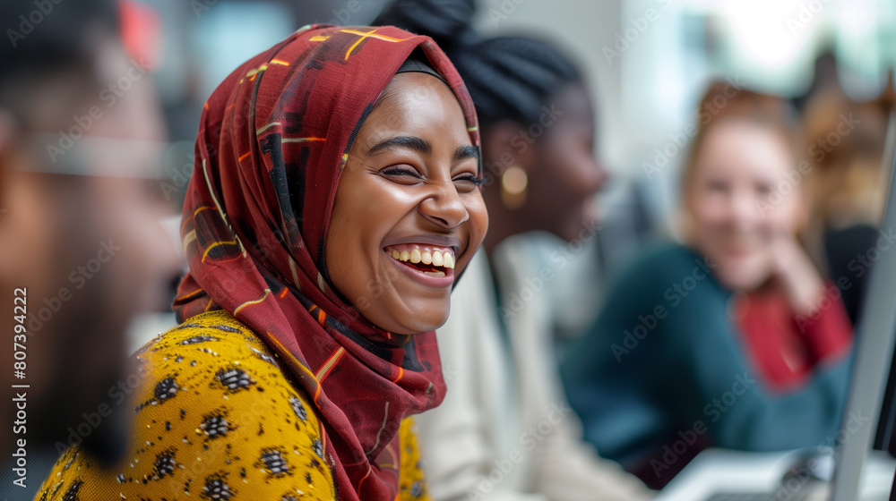 Black female muslim woman laughing with colleagues in diverse inclusive ...