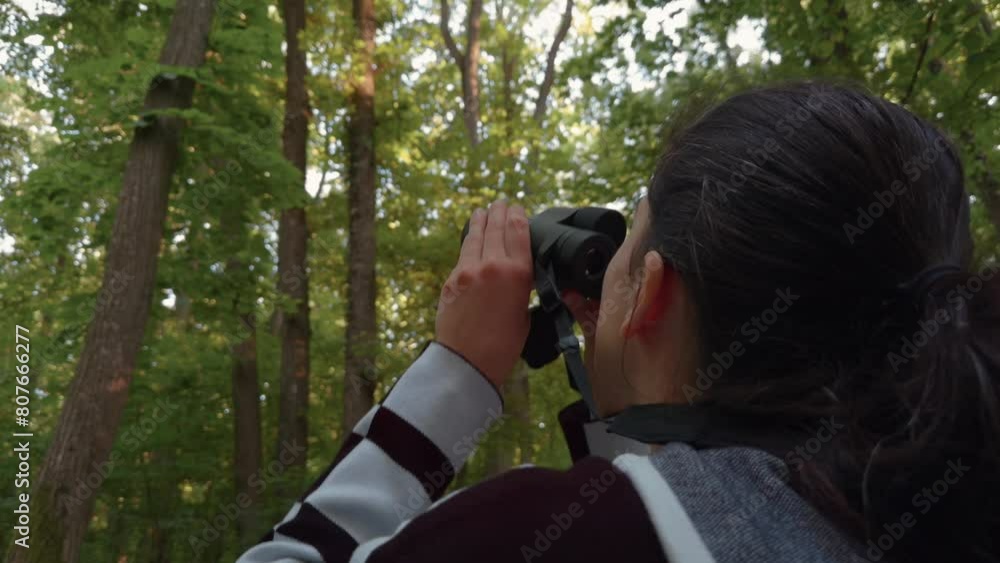 Birdwatching. 4K video with a woman filmed from behind while searching ...