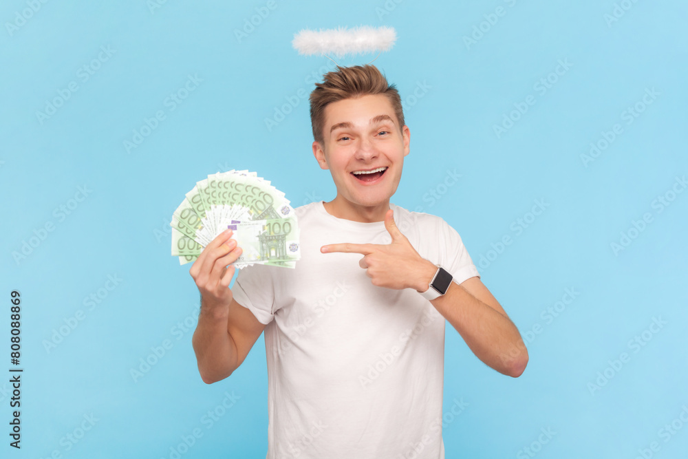 Portrait of rich angelic positive man wearing white t-shirt with nimb ...