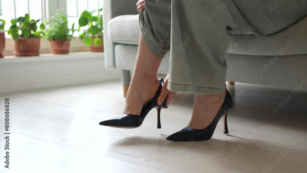 Woman taking off heel examining callus from tight uncomfortable shoes ...