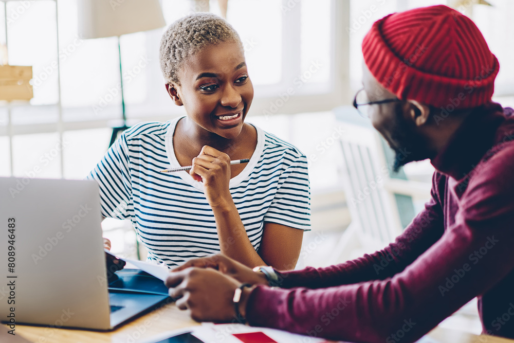Smiling african american woman talking to her colleague cooperating on ...