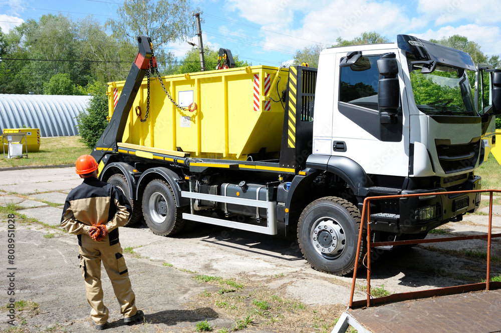 Worker controlling radioactive waste storage container loading on a ...