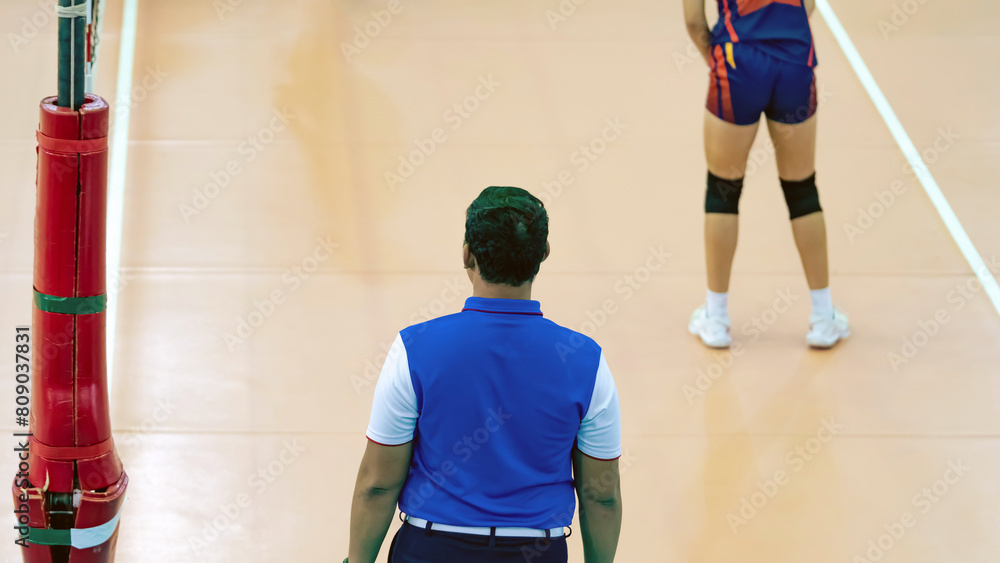Back view of male second volleyball referee stands and assists the main ...