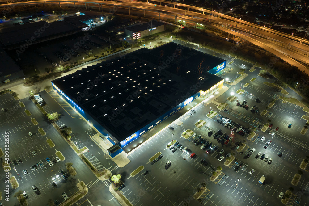 View from above of many parked cars on illuminated parking lot at night ...
