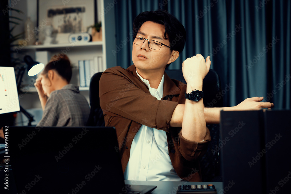 Sales manager working on desk with stretching body with arm ache at ...