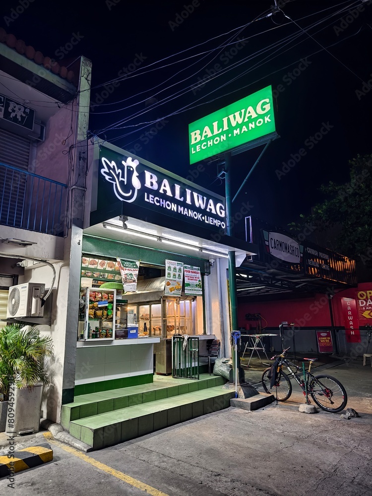 Baliwag Lechon Manok store lit up at night showcasing its vibrant ...
