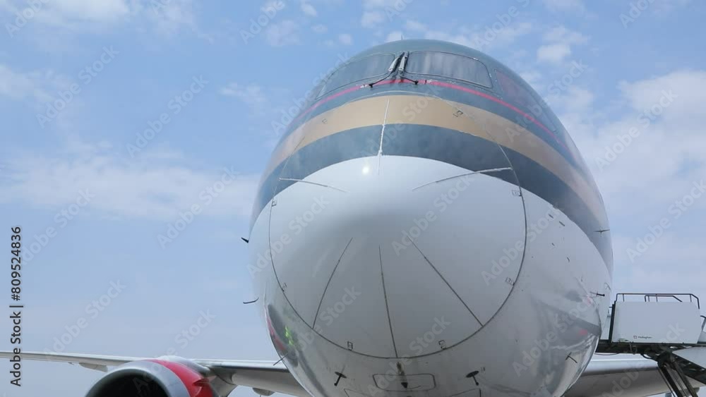 The scene captures the grounded airplane's nose, highlighting its ...