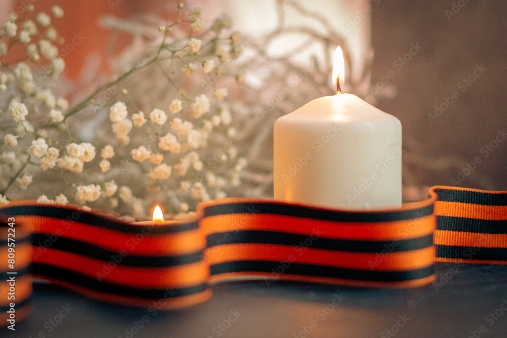 A burning candle and St. George's ribbon, a symbol of the victory of ...