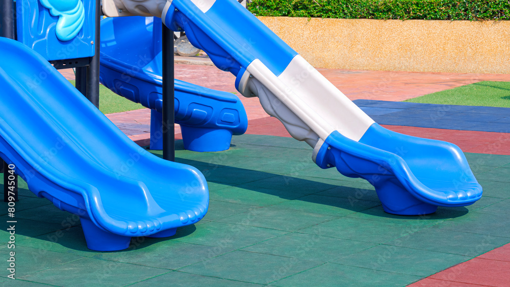 3 slides playground equipment on multicolor EPDM rubber floor with ...