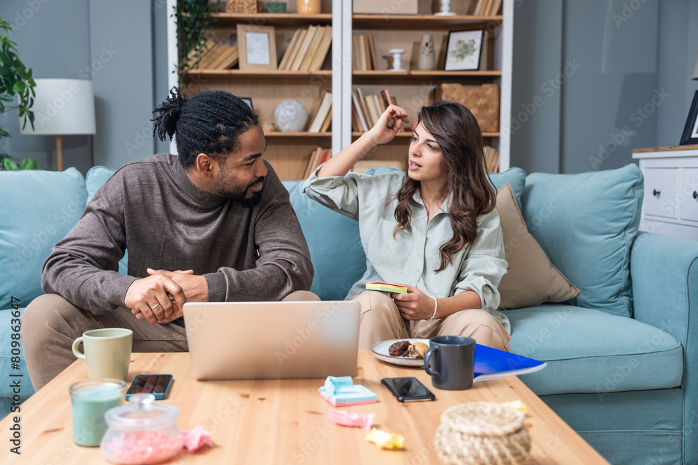 Positive hipster couple having fun while working together remotely at ...