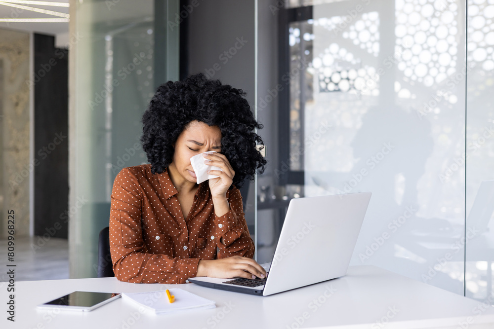 A young African American woman feeling emotional, crying at her office ...