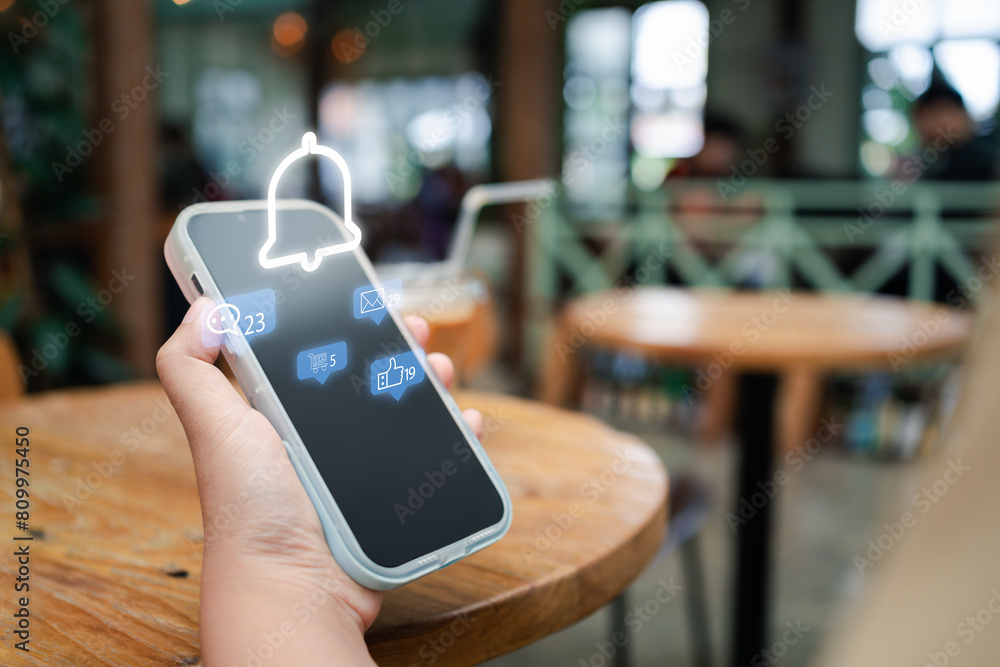 Hand holding smartphone showing notification with bell symbol, chat ...