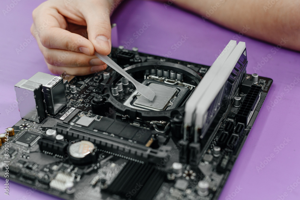 system administrator applying thermal paste to processor for installing into motherboard ...