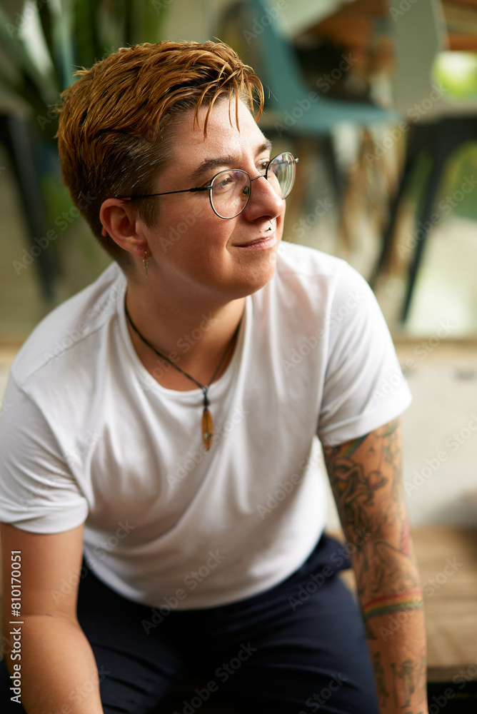 Positive transgender individual in casual setting, smiling confidently ...