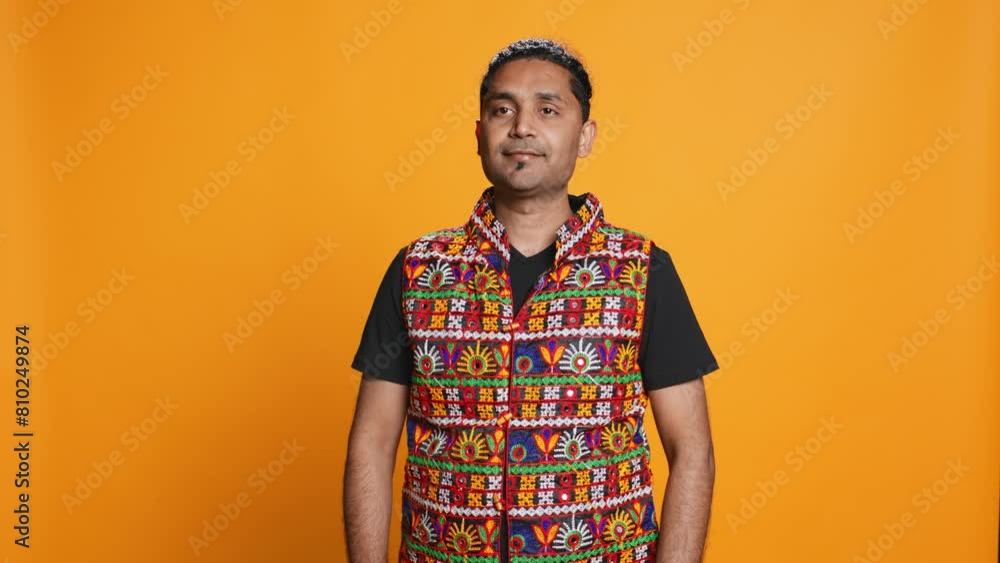 Portrait of jolly indian man with colorful garment smiling, looking ...