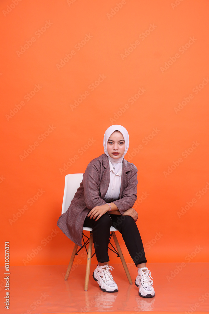Full length portrait of young Muslim Asian girl sitting in elegant ...