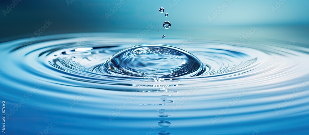 A captivating image of a water droplet falling onto the water s surface ...