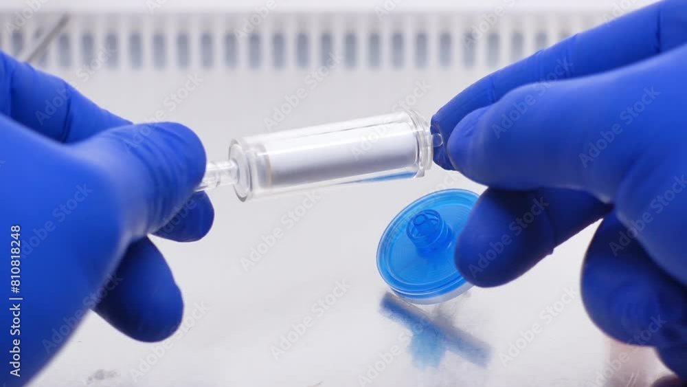 A scientist inspects filters used to filter bacterial cell cultures ...