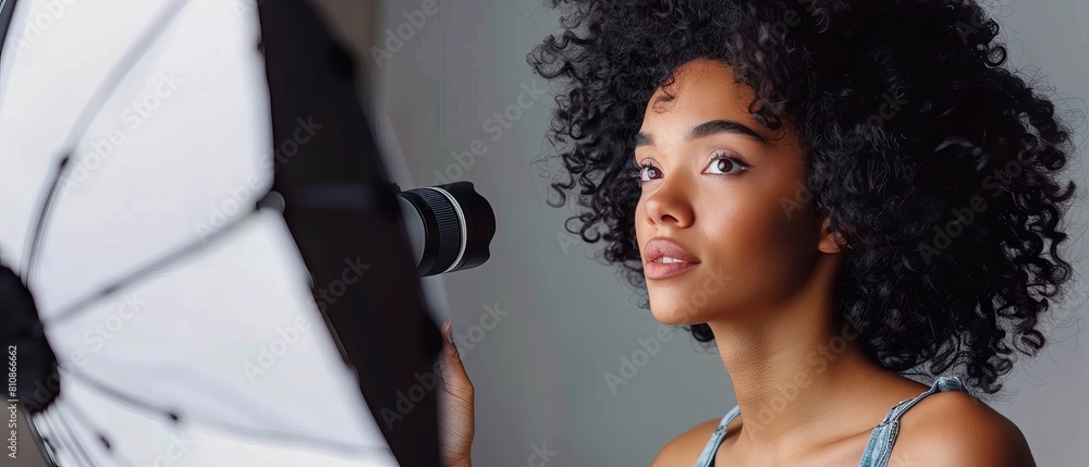 The beautiful black model poses for the photographer, who uses a ...