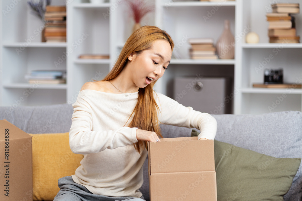 Young Woman Unpacking Box At Home, Expressing Excitement, Casual ...