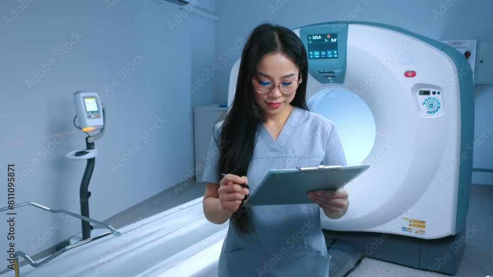 Asian doctor posing at background of magnetic resonance scanner ...
