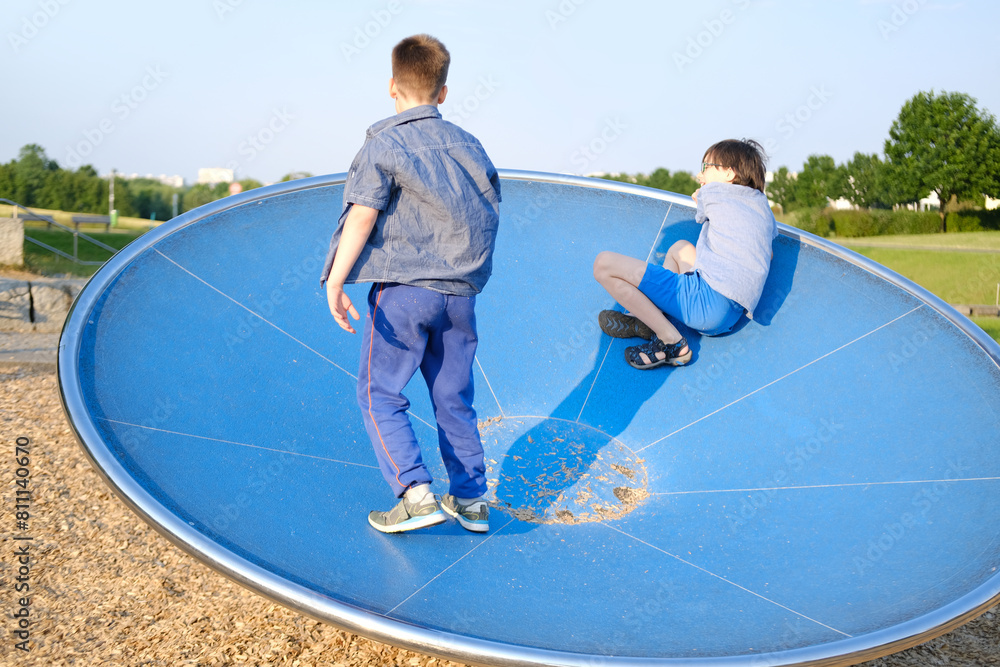 two boys, children 9-10 years play in playground, try to keep balance ...