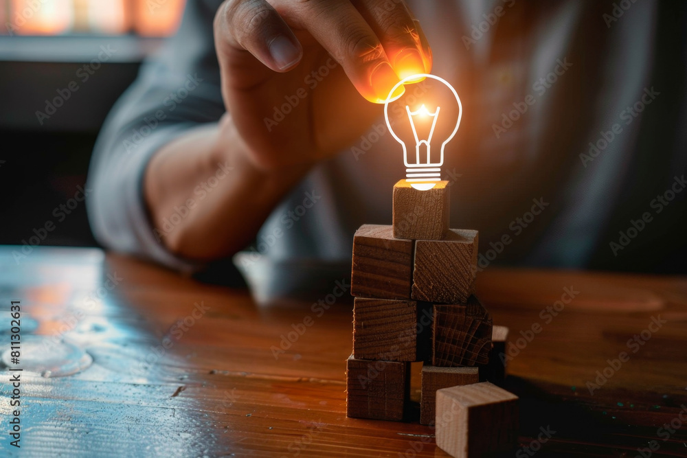 Wooden cubes with icons of head and light bulb on them, hand picking ...