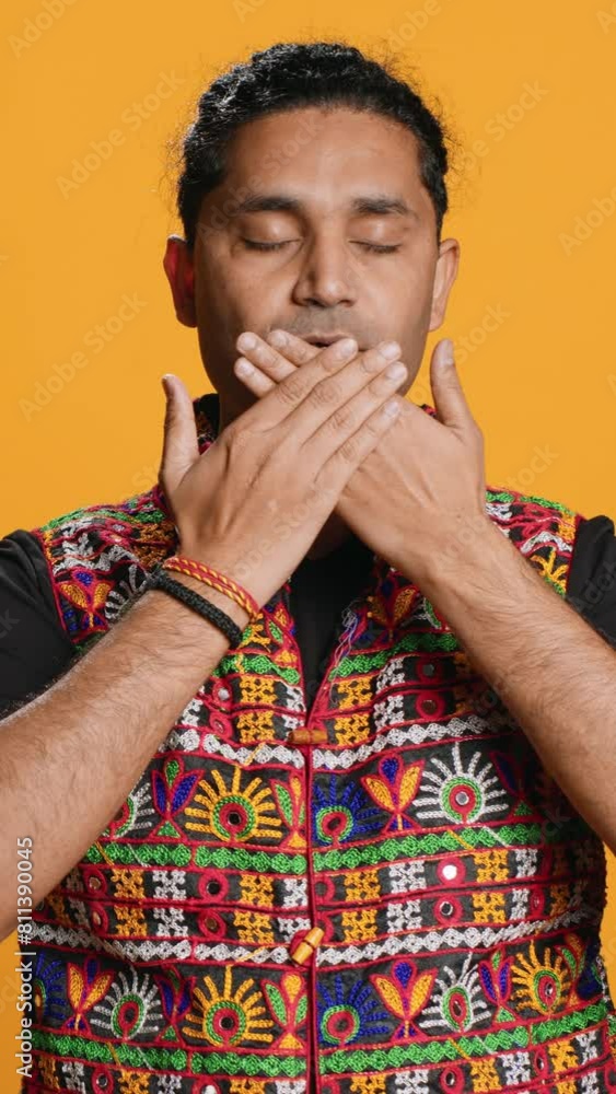 Vertical video Man wearing traditional indian clothing covering eyes ...