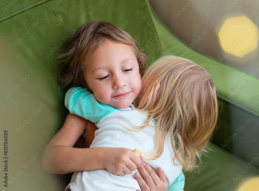 A little girl hugs her brother. Friendly little brother and sister hug ...