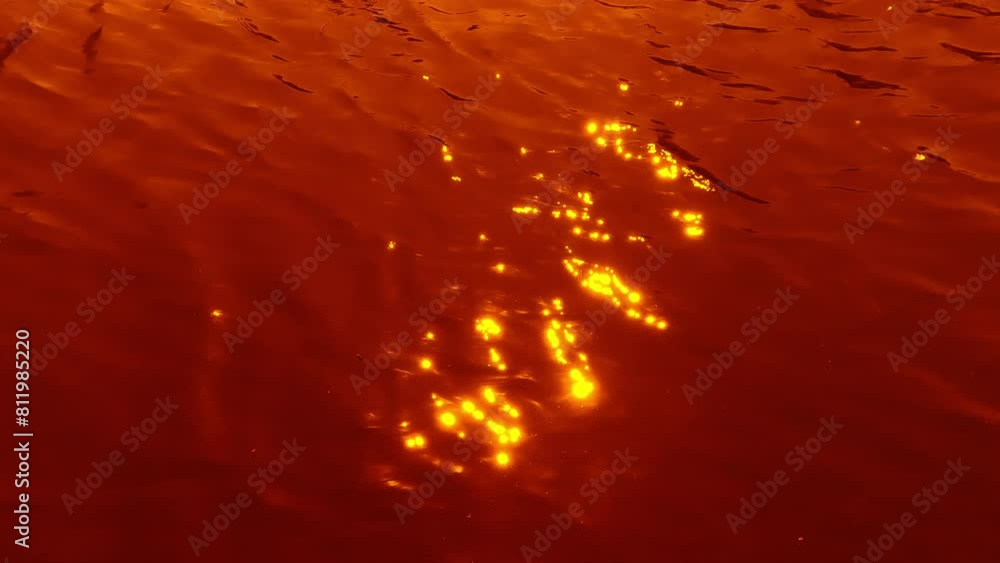 Close-up of red water surface with sun glare and ripples, Very large ...