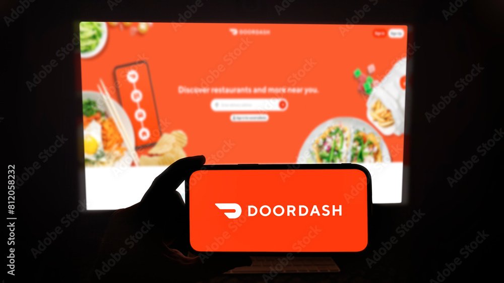 Doordash food delivery app running on a modern mobile phone. The smartphone is being held in ...
