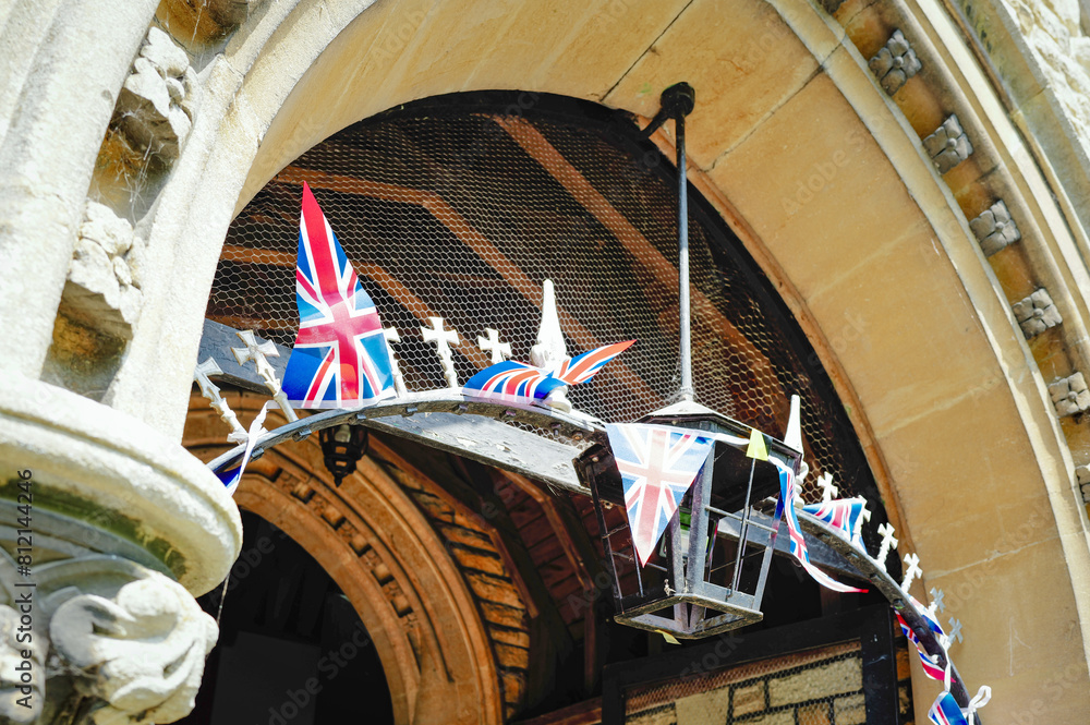 Union Jack bunting seen strewn in an old English church porch. The ...