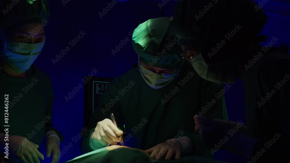An intense scene in an operating room where a surgical team is ...
