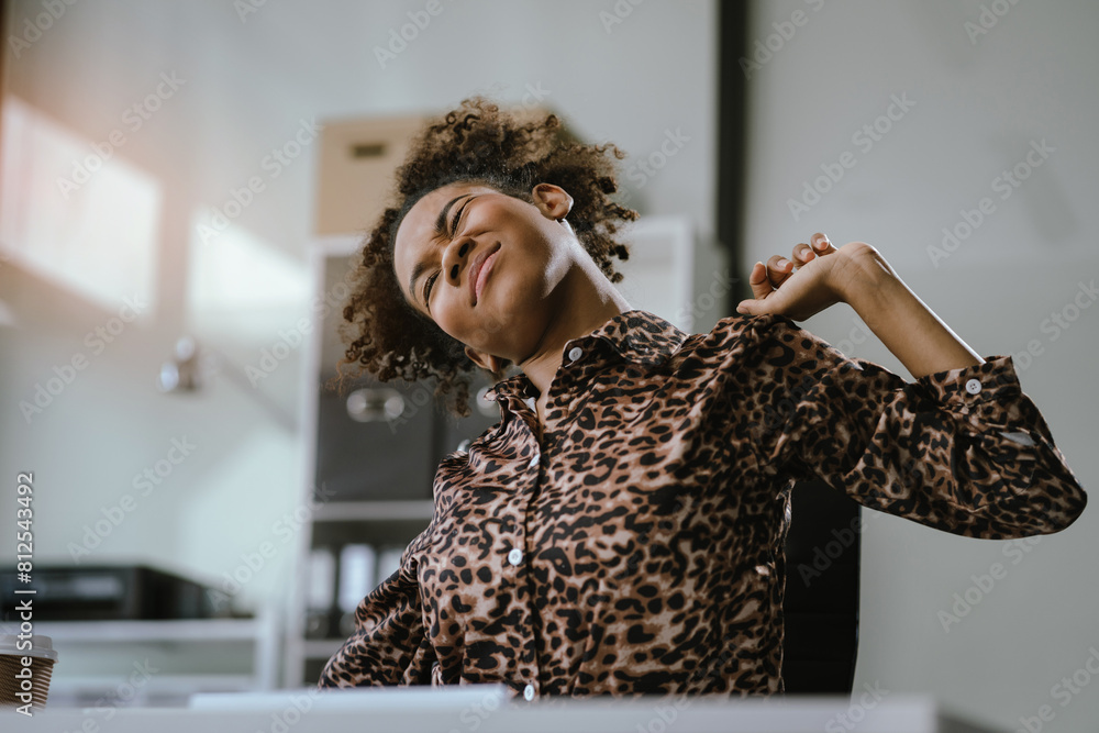 Businesswoman is doing a stretchy posture due to sitting in the office ...