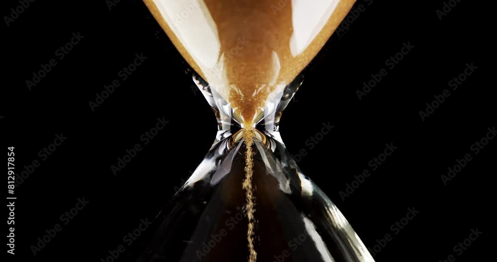 Hourglass. Sands move through hour glass. Sandglass close-up on a black ...