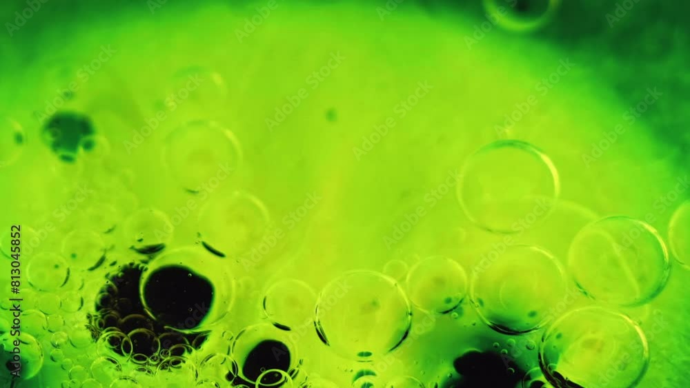 Acid bubbles. Neon fluid. Oil foam. Blur bright glowing green yellow color liquid molecular ...