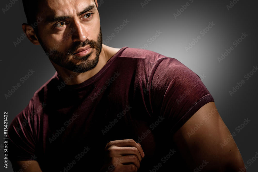 Brutal style portrait of handsome muscular young man posing on dark ...