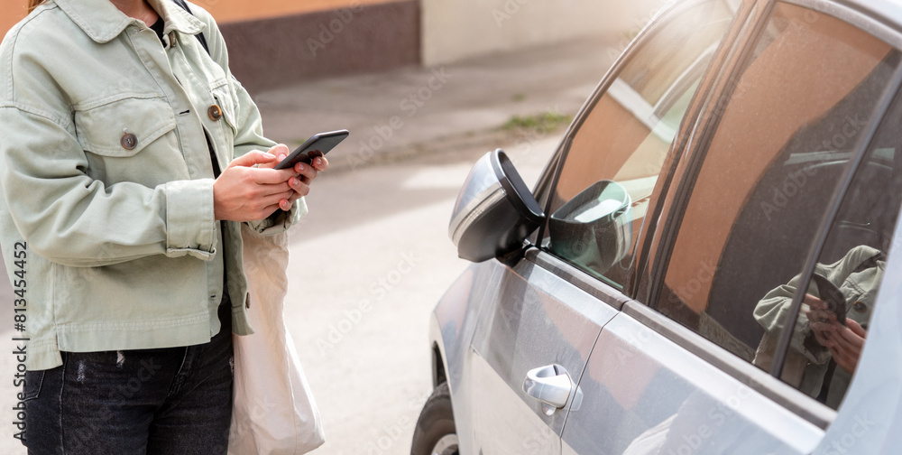 The Woman Unlocks A Free Floating Car Sharing Service Using Her Smartphone On The Street In The