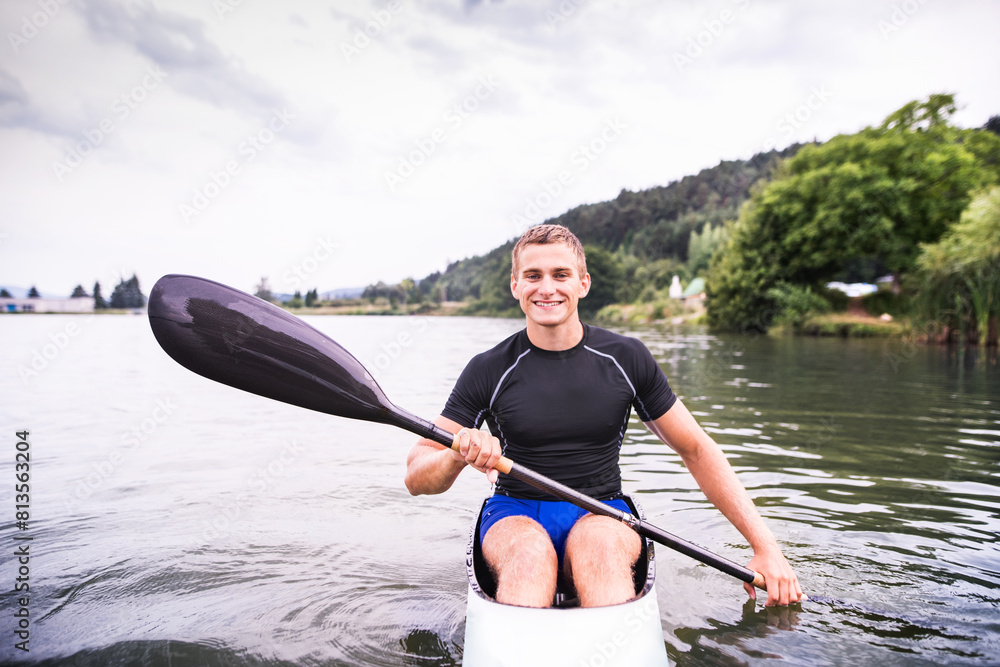 Canoeist man sitting in canoe holding paddle, in water. Concept of ...