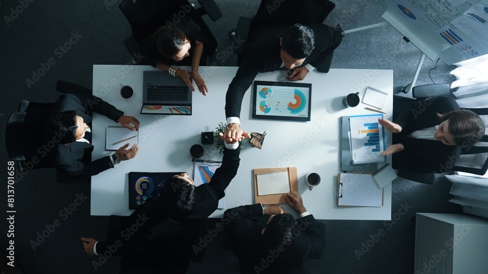 Top down aerial view of smart manager pointing at financial graph on ...