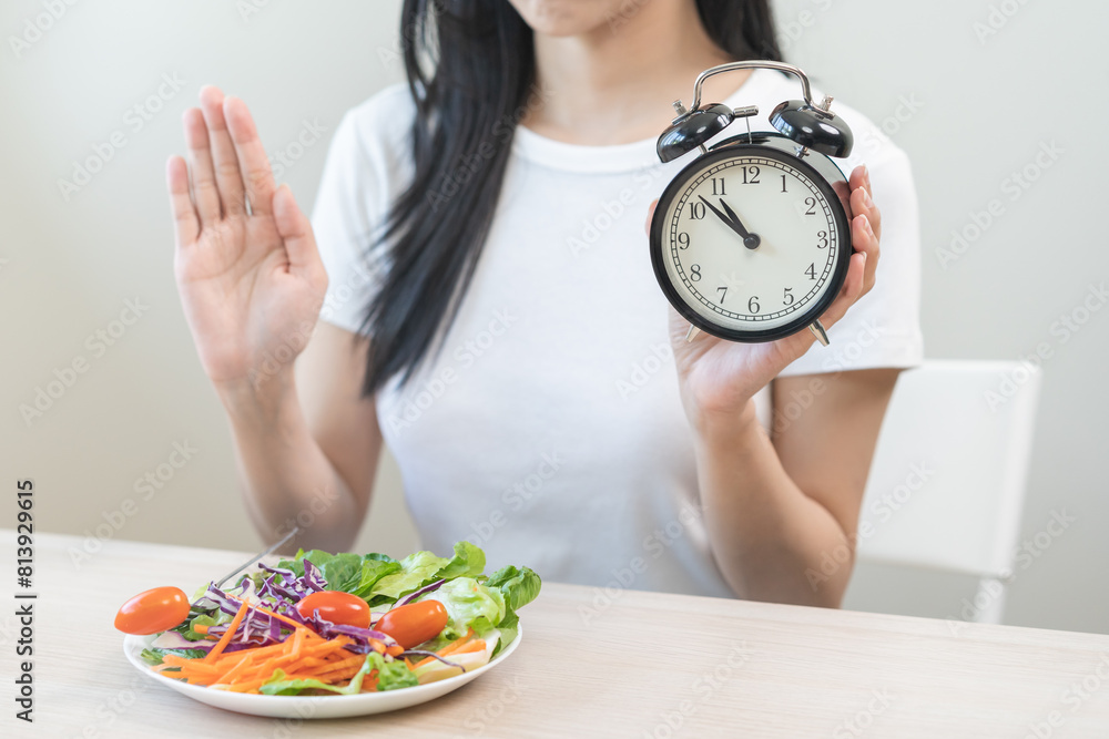 Intermittent fasting with clock, asian young woman dieting hand refuse ...