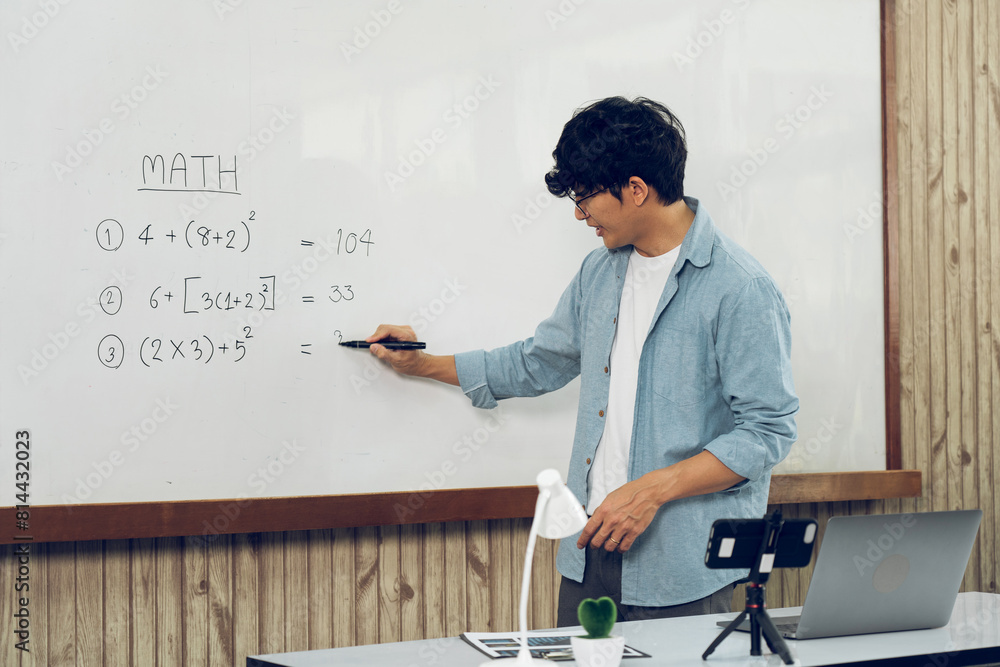 Teacher explaining the numbers on the board while video calling with ...