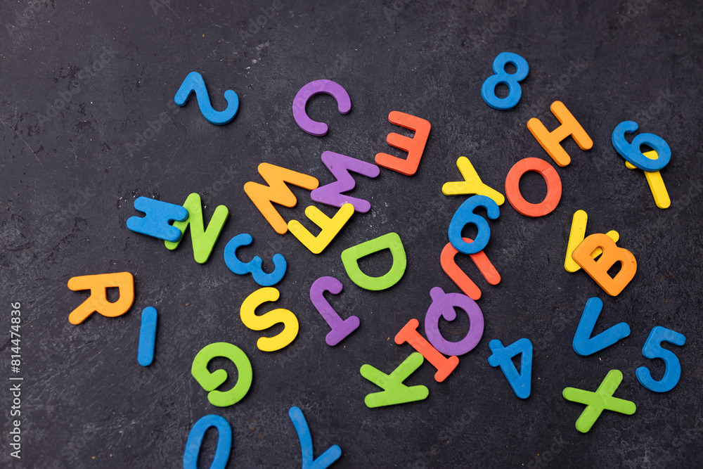 Top view of letters of the English alphabet scattered on a black ...