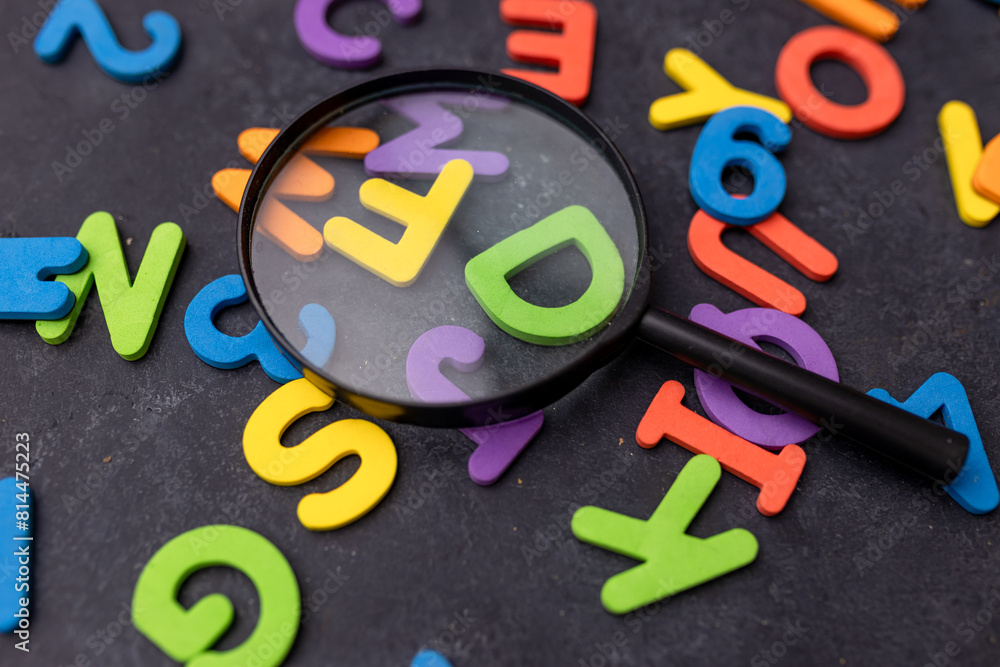 Magnifying glass with many wood letters of English alphabets, learning ...